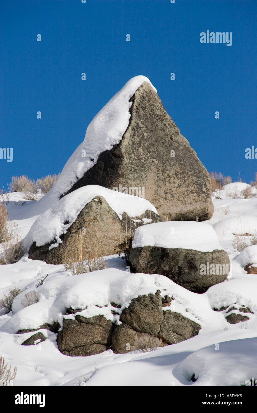 Prevailing wind has blown snow to one side of this rock formation Stock ...