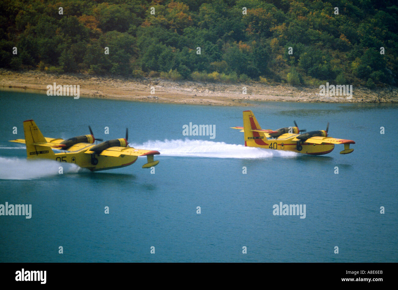 Aerial view of 2 Canadair firefighting water bomber airplanes scooping ...