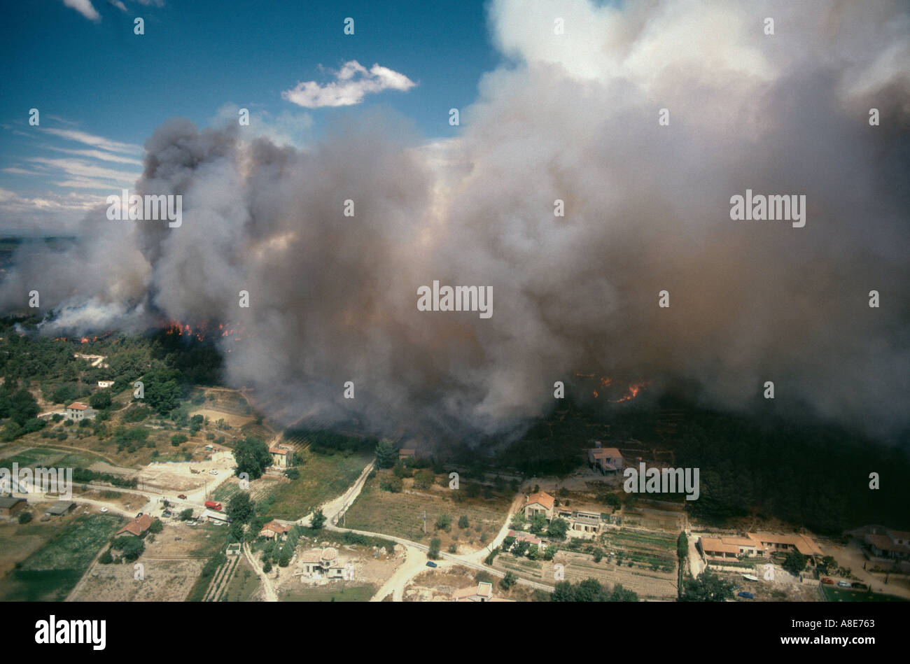Aerial view of a wildfire threatening city houses, forest fire cloud of ...