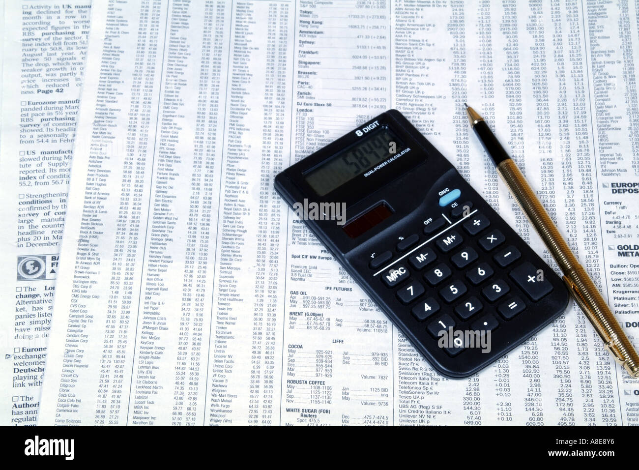 checking list of stocks and shares markets in detail on newspaper page ...