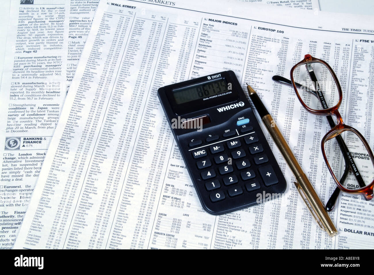 checking list of stocks and shares markets in detail on newspaper page ...
