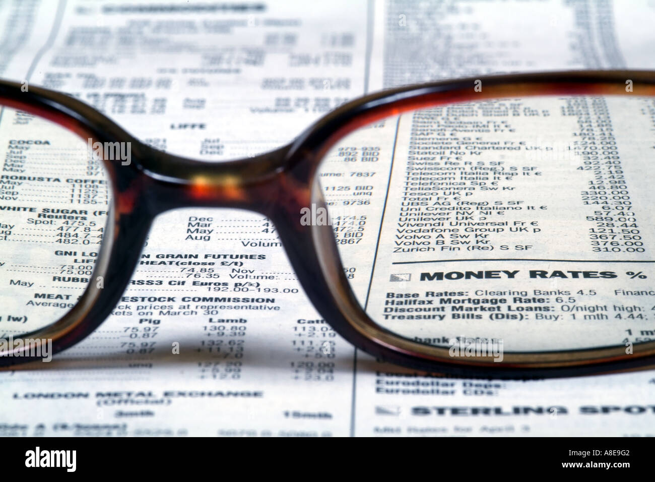 checking list of stocks and shares markets in detail on newspaper page ...