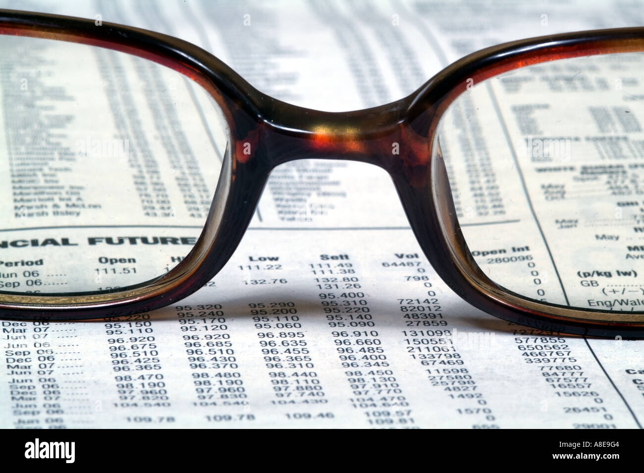 checking list of stocks and shares markets in detail on newspaper page ...
