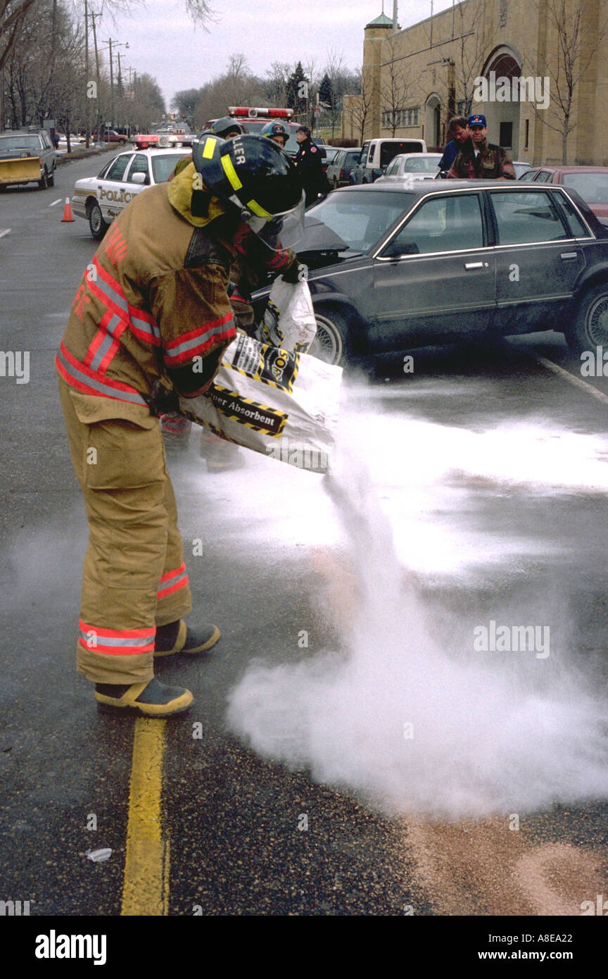 Fireman spreading anti-fire material at emergency car accident site. St ...