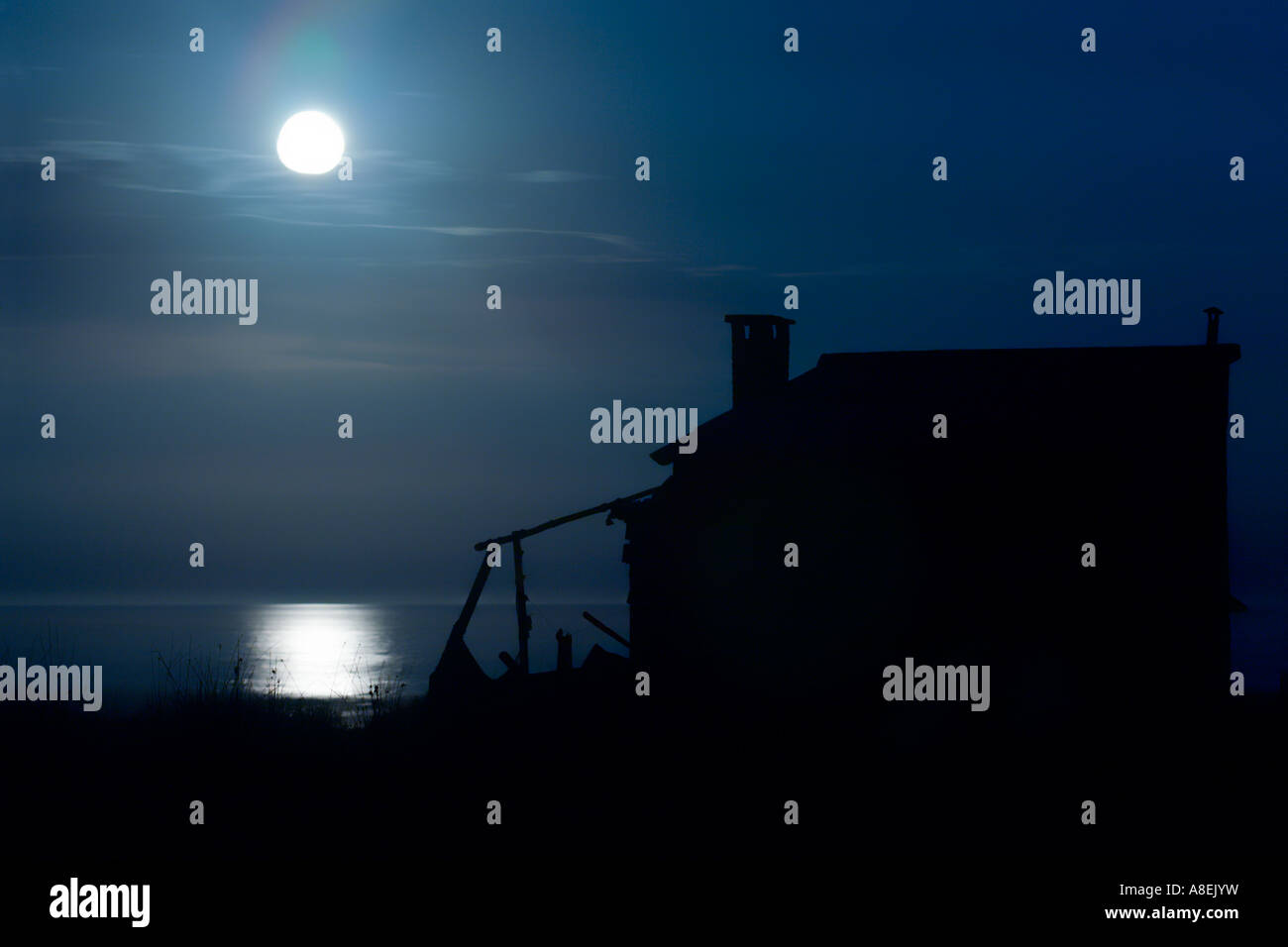 Small house in a beach in a full moon night Stock Photo - Alamy