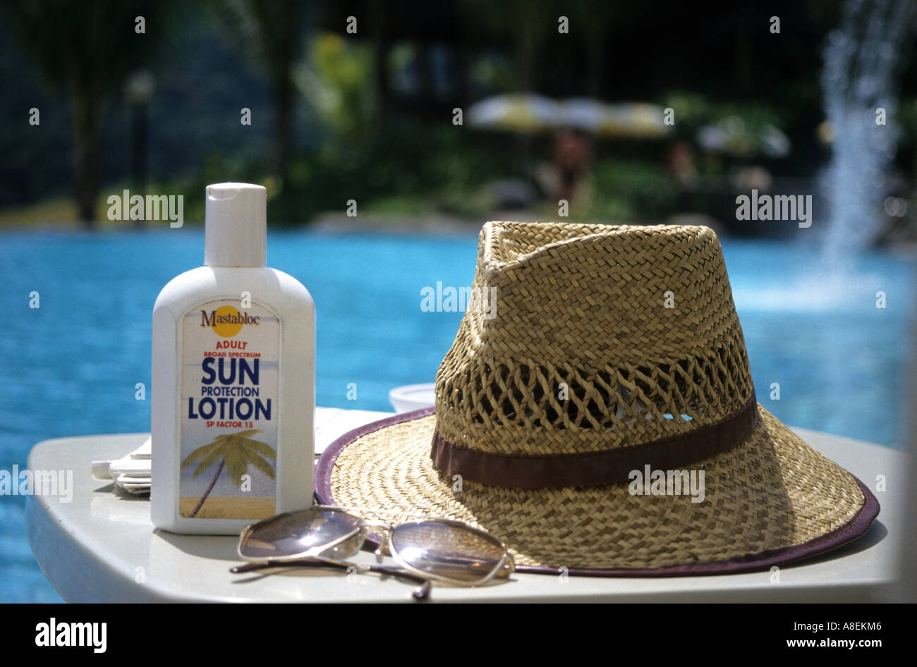 Swimming pool scene showing holiday accessories: suntan lotion ...