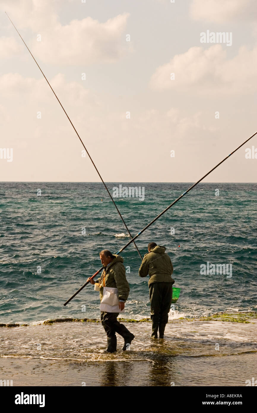 Stock photo of two fishermen crossing paths with long fishing poles ...