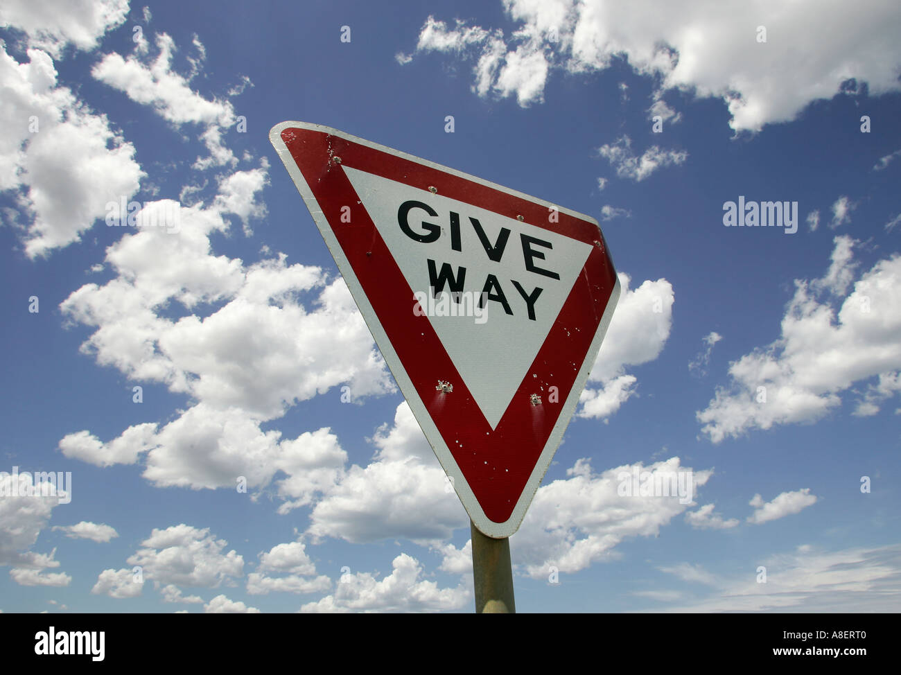 Give Way road sign against blue sky with white clouds Stock Photo - Alamy