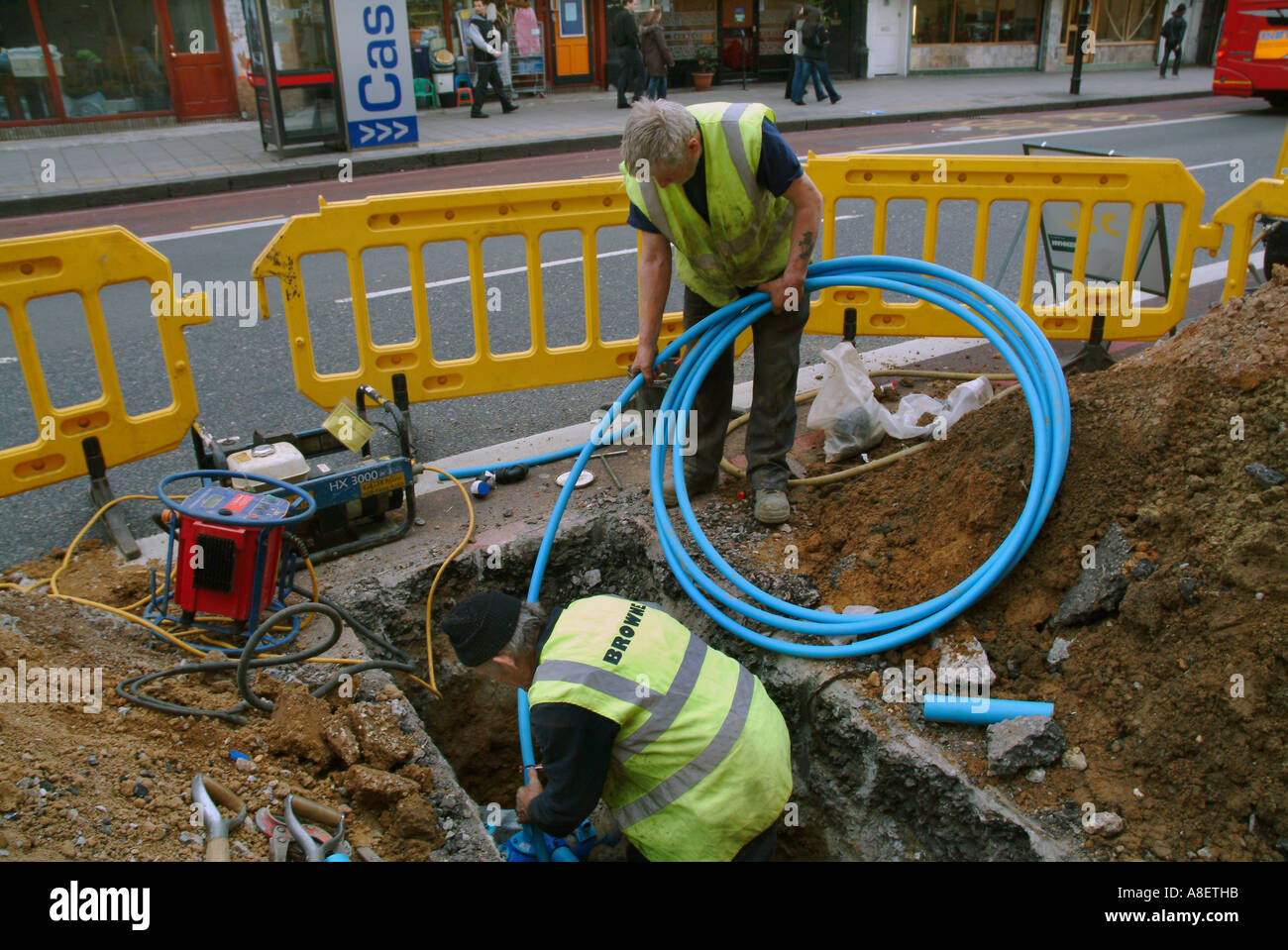TWO WORKERS PIPING THE UNDERNEATH OF THE ROAD Stock Photo - Alamy