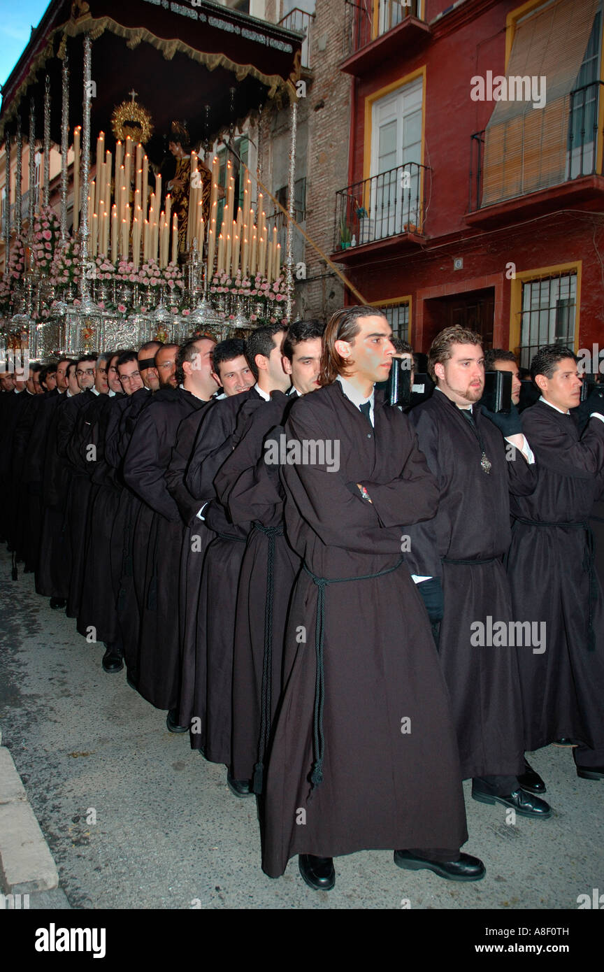 Black robed men carry statue of Virgin Mary in Malaga street procession ...