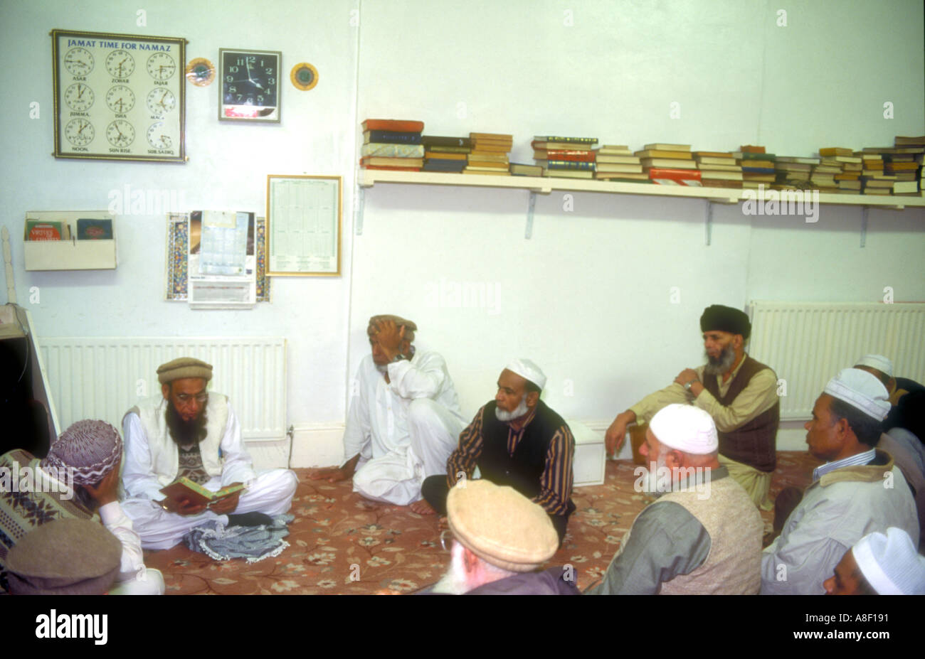 A group of Muslim men listening to a reading from the Koran inside a ...