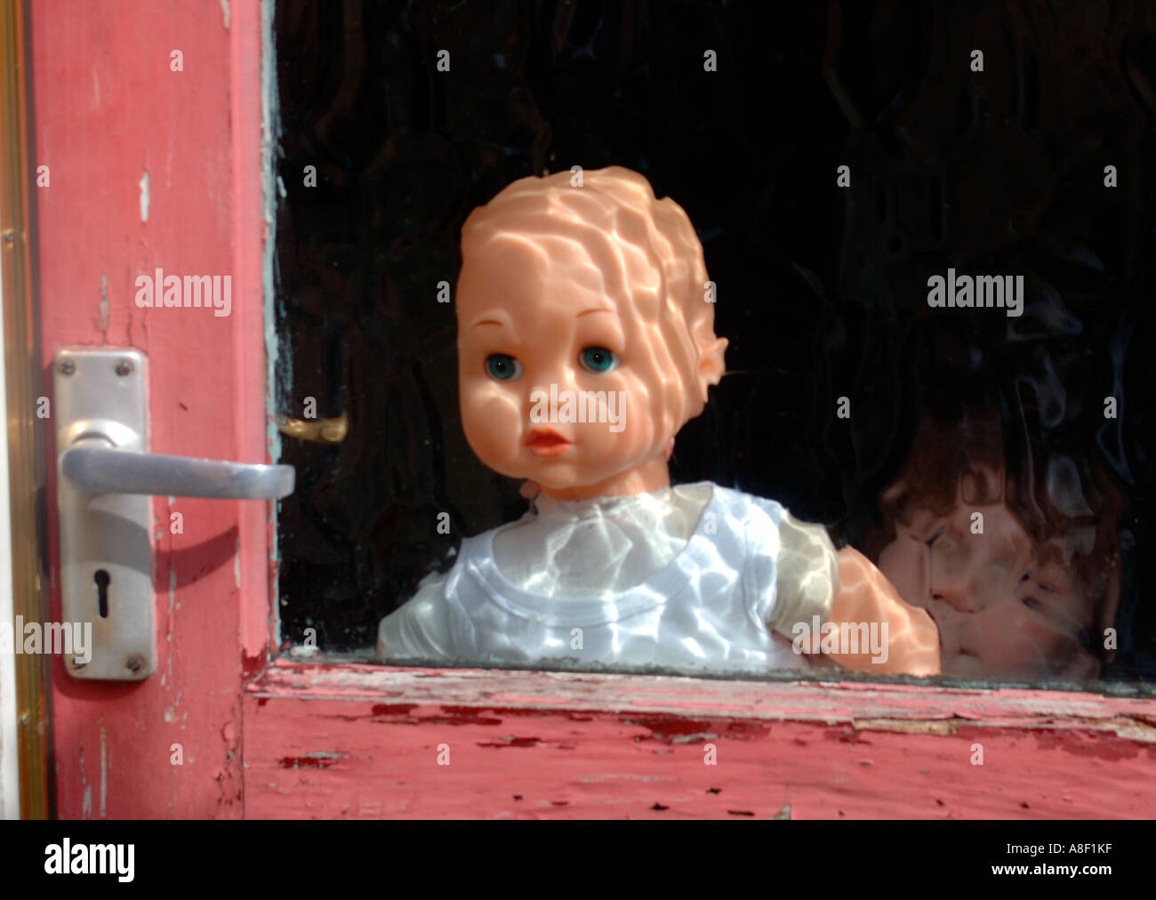 Doll Behind Glass Door Stock Photo - Alamy
