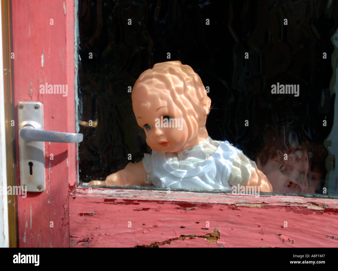 Doll Behind Glass Door Stock Photo - Alamy