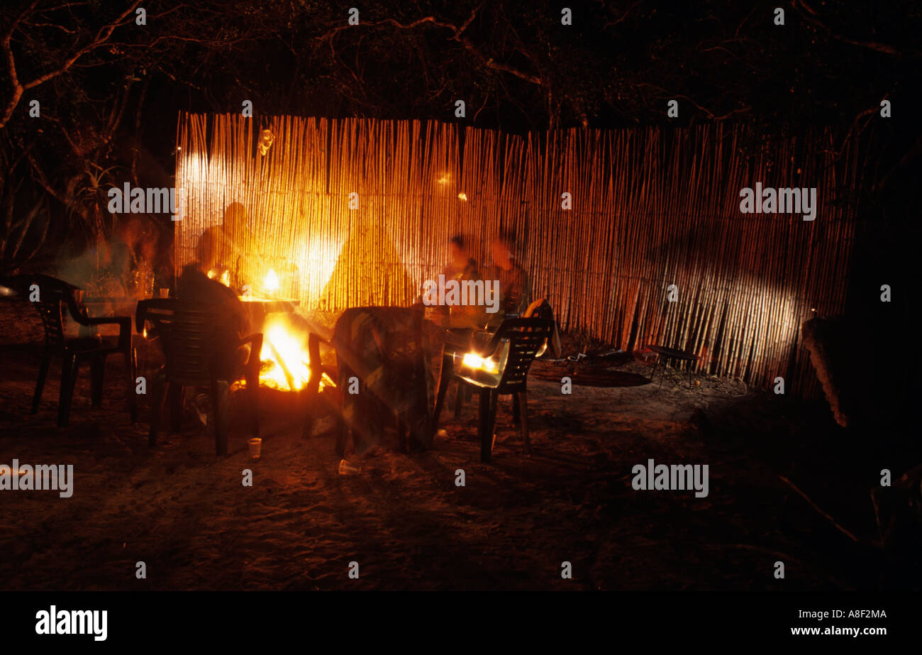 People sit around a glowing campfire in the African bush Stock Photo ...