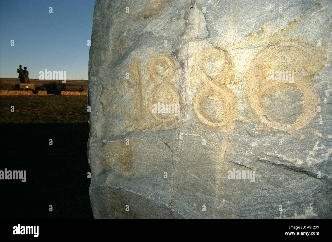 A monument to the 1820 British settlers is seen behind a stone wall ...