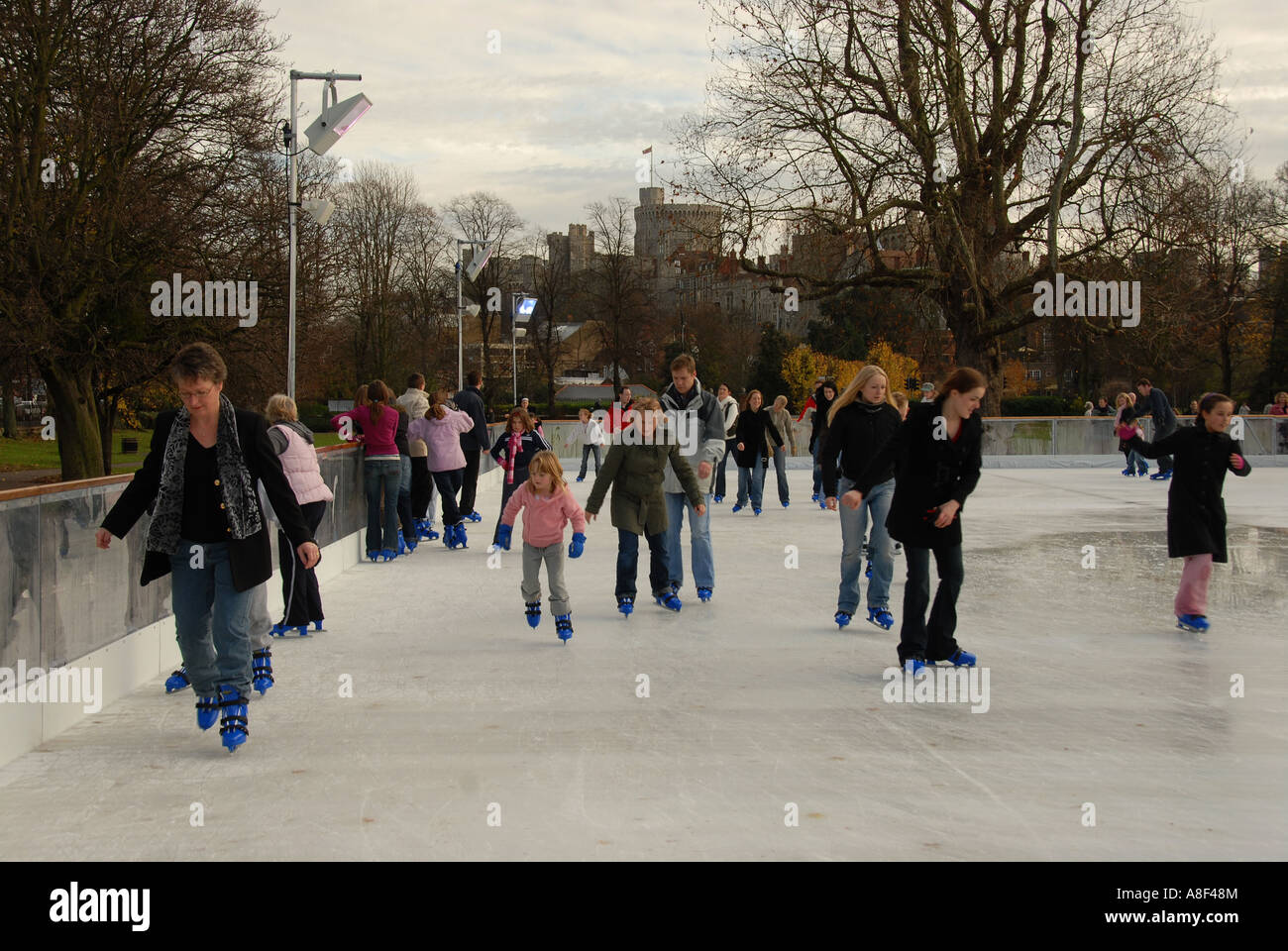 Visitors to Windsor, England, having fun on a temporary skating rink ...