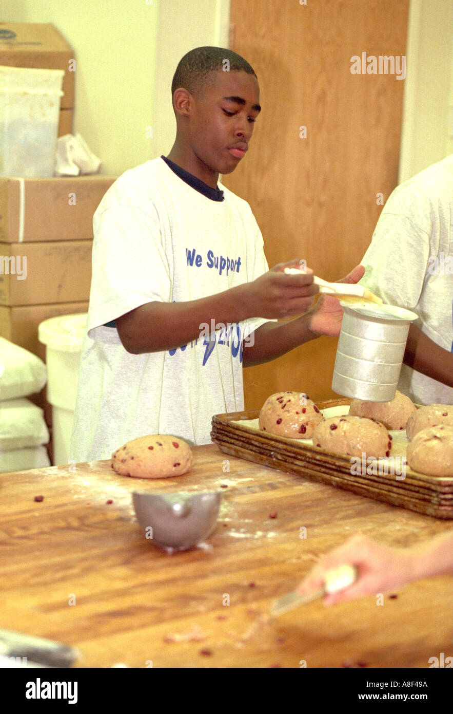 Youth Express teen buttering bread for baking fundraiser age 16. St ...