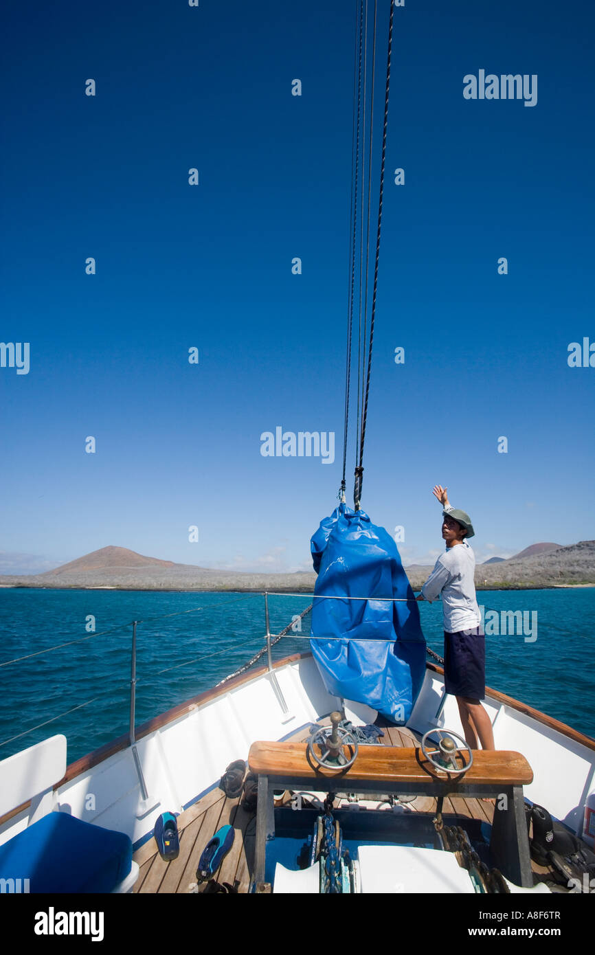 A sailer raising the sail on a motor sailing boat Stock Photo - Alamy