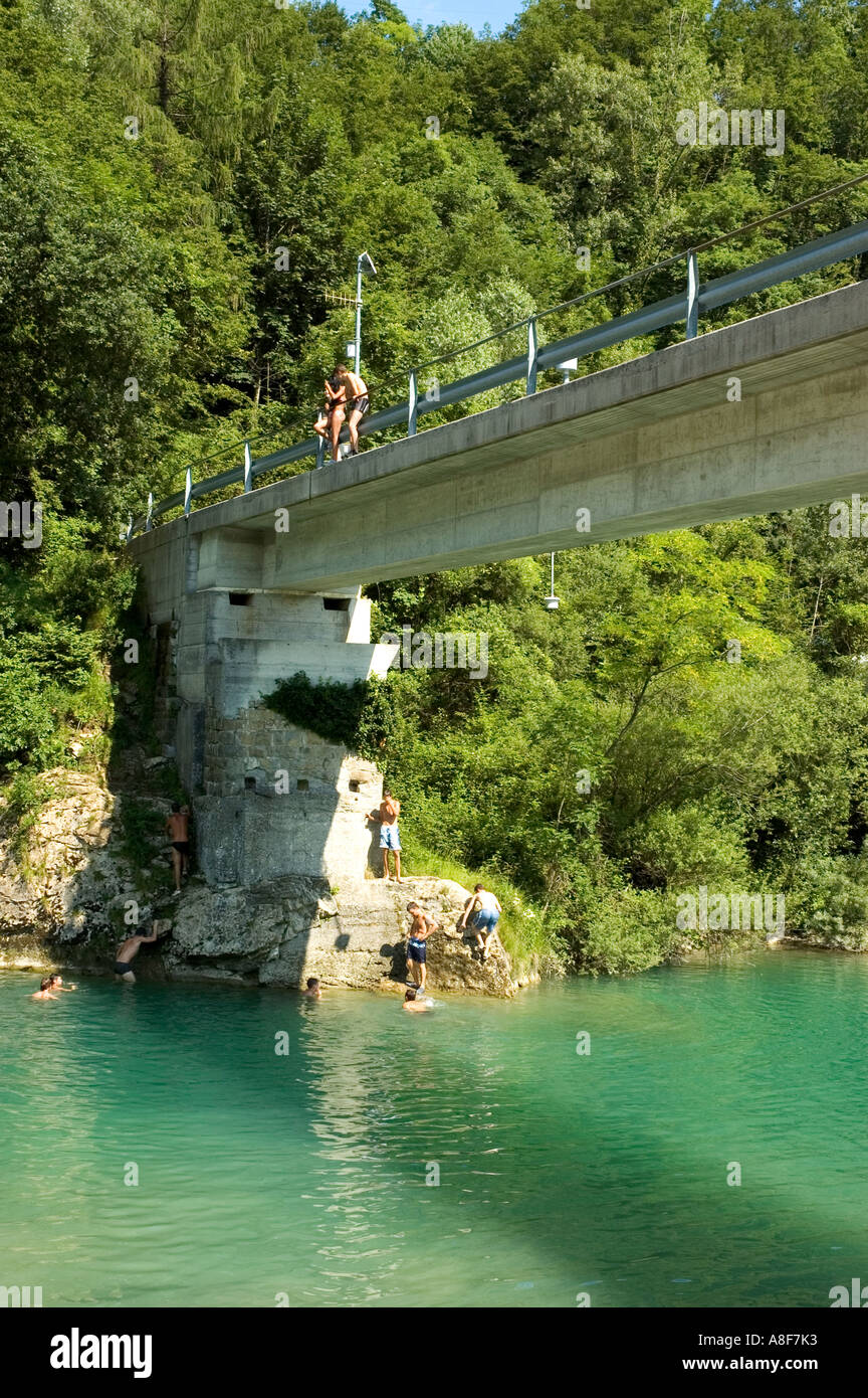 young people jump into green water from a bridge - meduno- region of ...