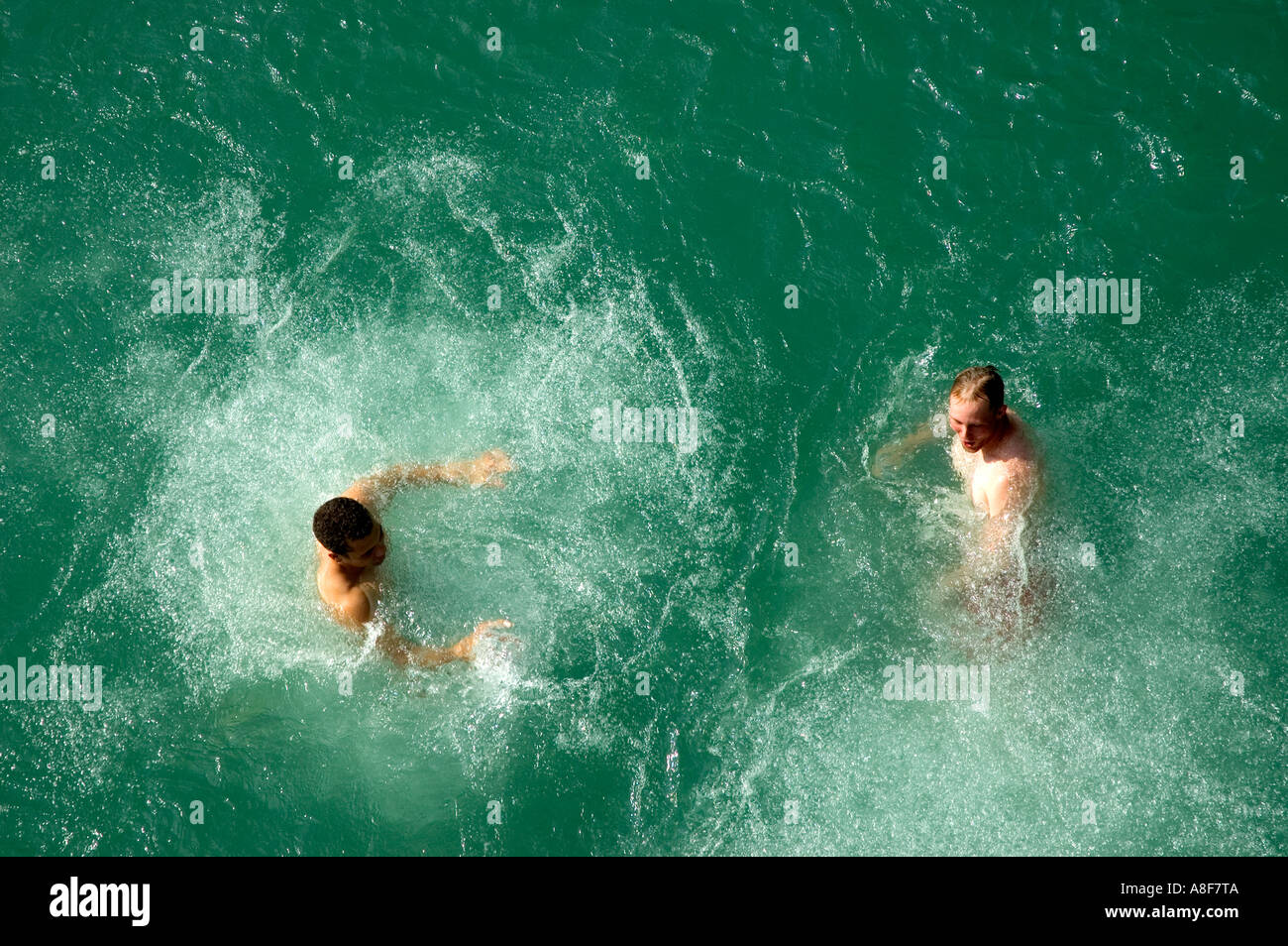 young people jump into green water from a bridge - meduno- region of ...