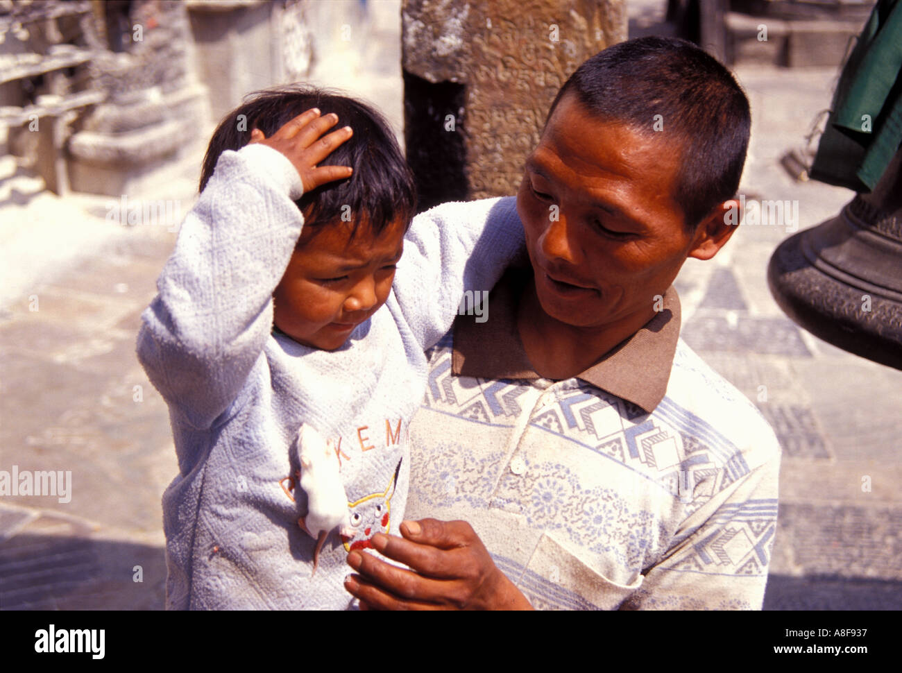 Nepal Father teases his son mouse with pet mouse Stock Photo - Alamy