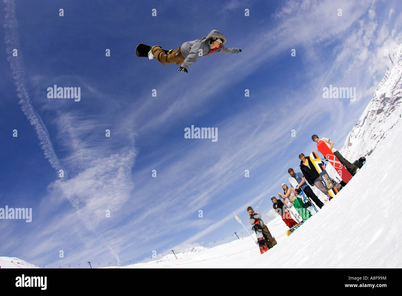 Snowboader performing a backflip in front of an appreciative crowd in ...
