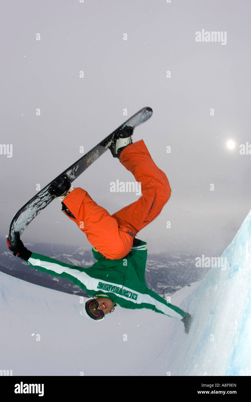 Snowboarder inverted in half pipe grabbing board Stock Photo - Alamy