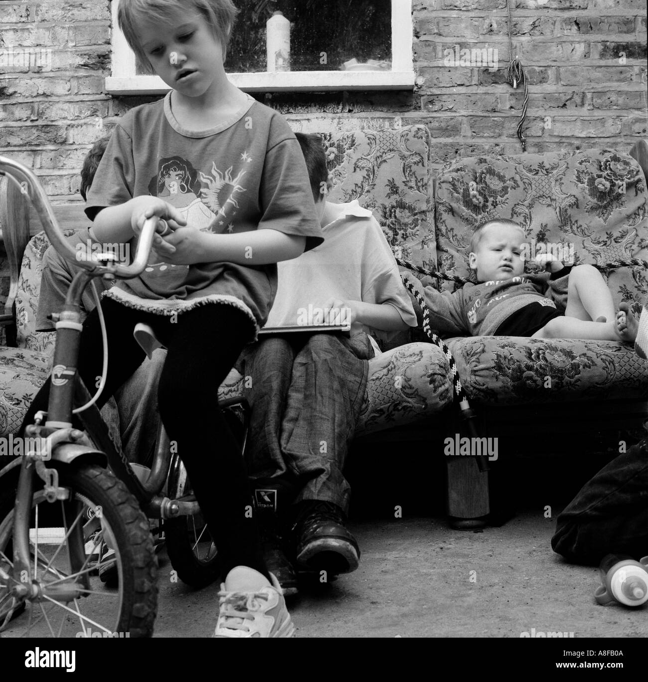 Children of a low income family play in the back yard of their home ...