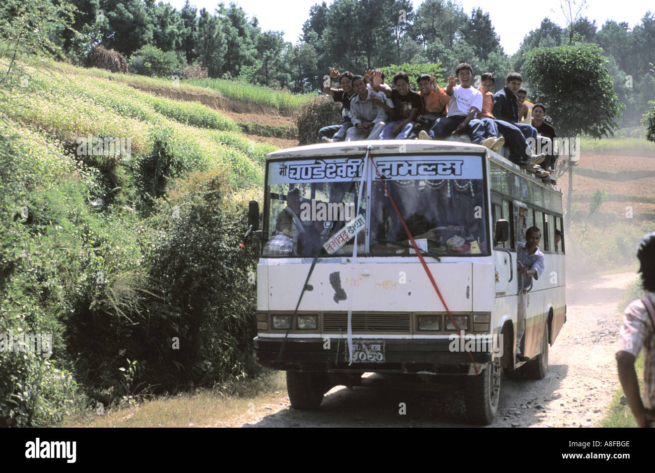 Overcrowded transport with people sitting on top of the local bus in ...