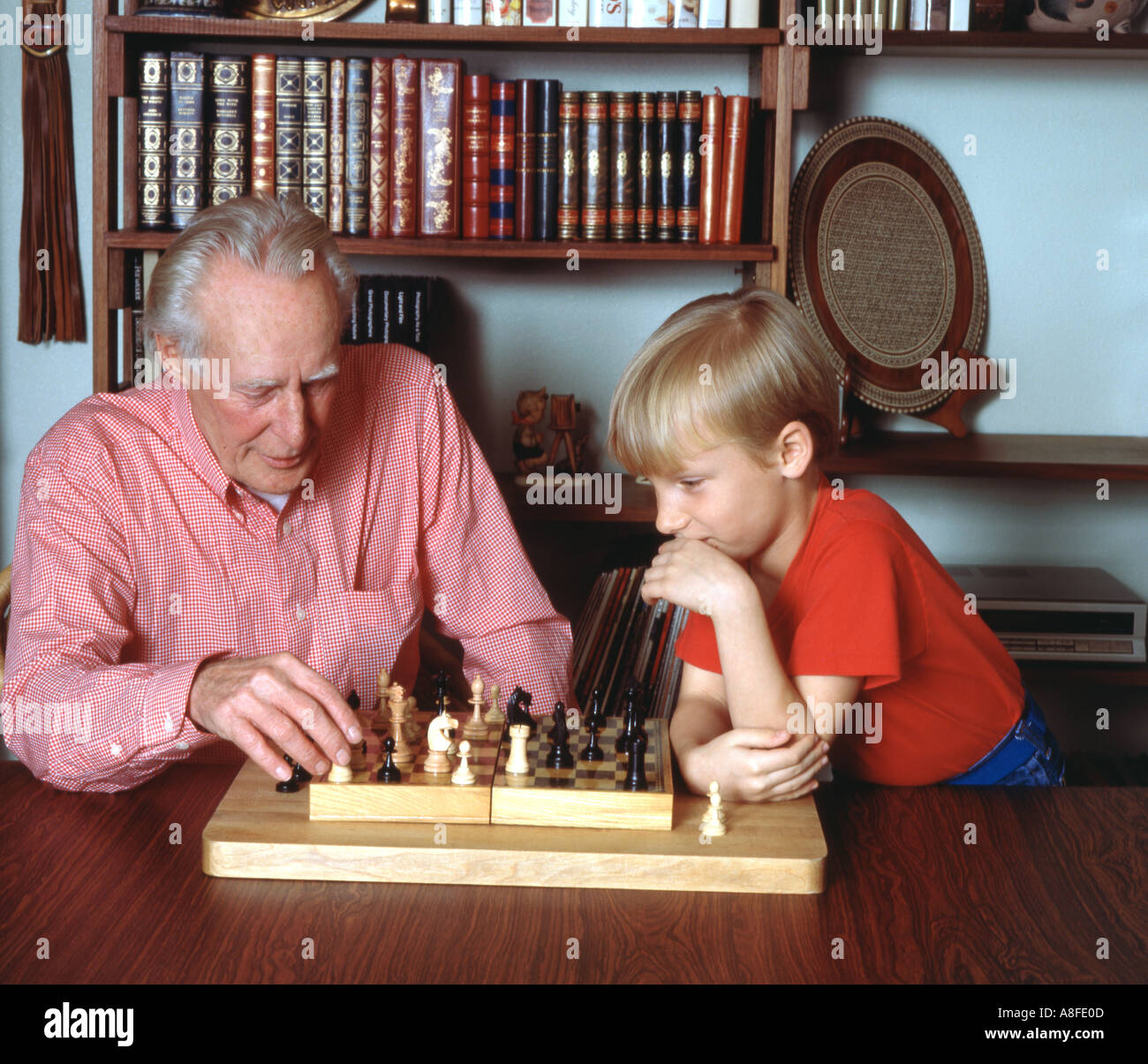 Grandfather and grandson playing chess in a home background Stock Photo ...