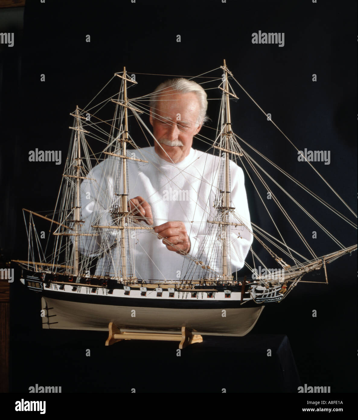 Older gentleman building a ship model Stock Photo - Alamy