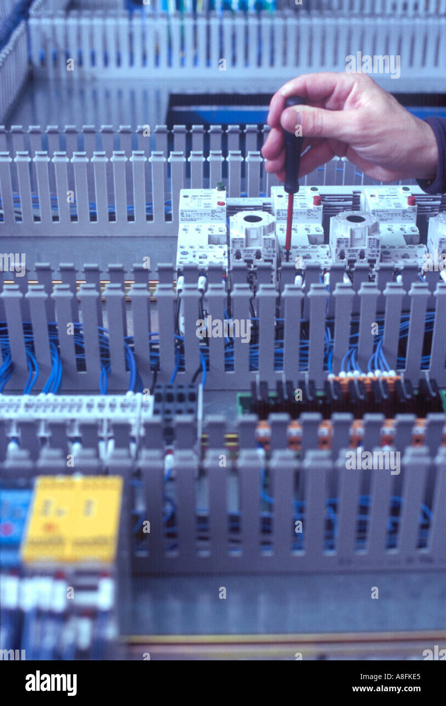 hand holding screwdriver installing electrical components on ...