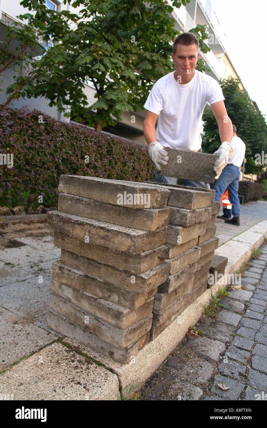 Worker collecting the stones from the pedestrian road Stock Photo - Alamy