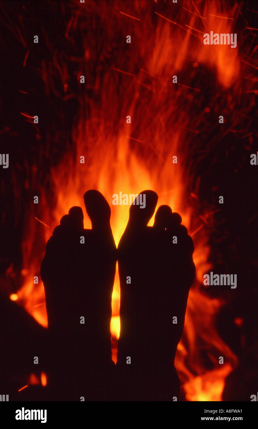 Campers feet silhouetted against a roaring campfire Australia Stock ...