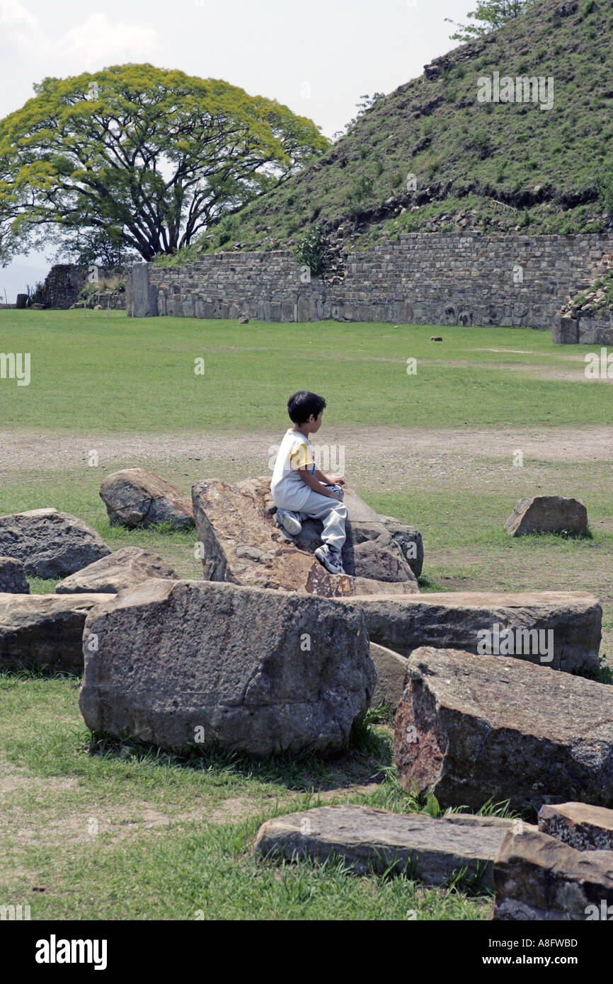 Child sitting on a pile of rocks at Monte Alban archeologic site near ...
