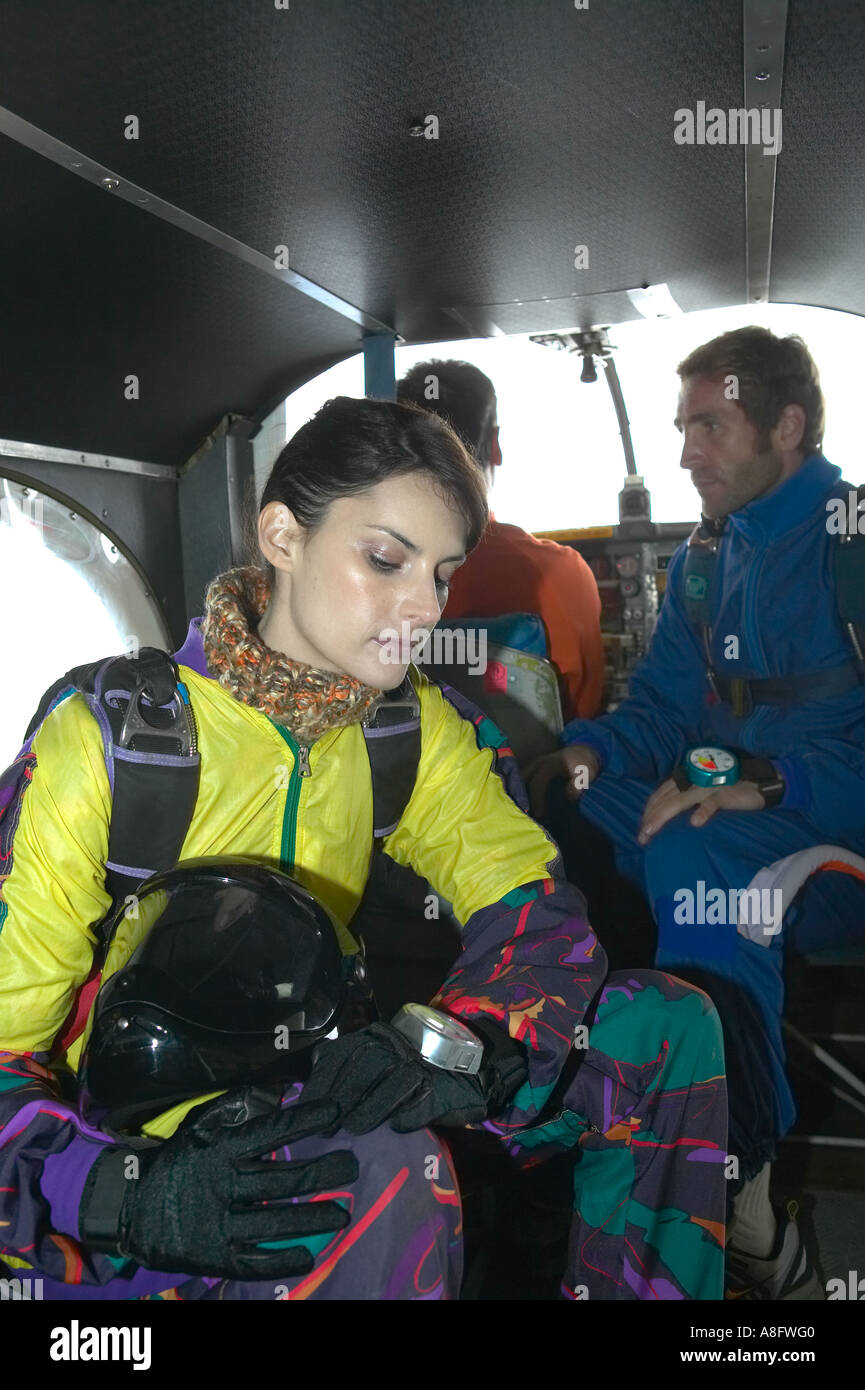 Pilote and a couple wearing parachute gear inside plane, concentrated ...