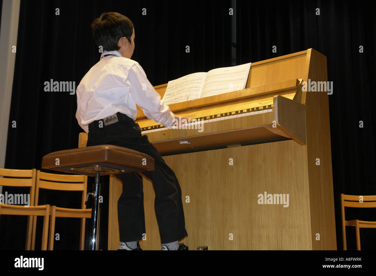 Boy play piano on stage Stock Photo - Alamy