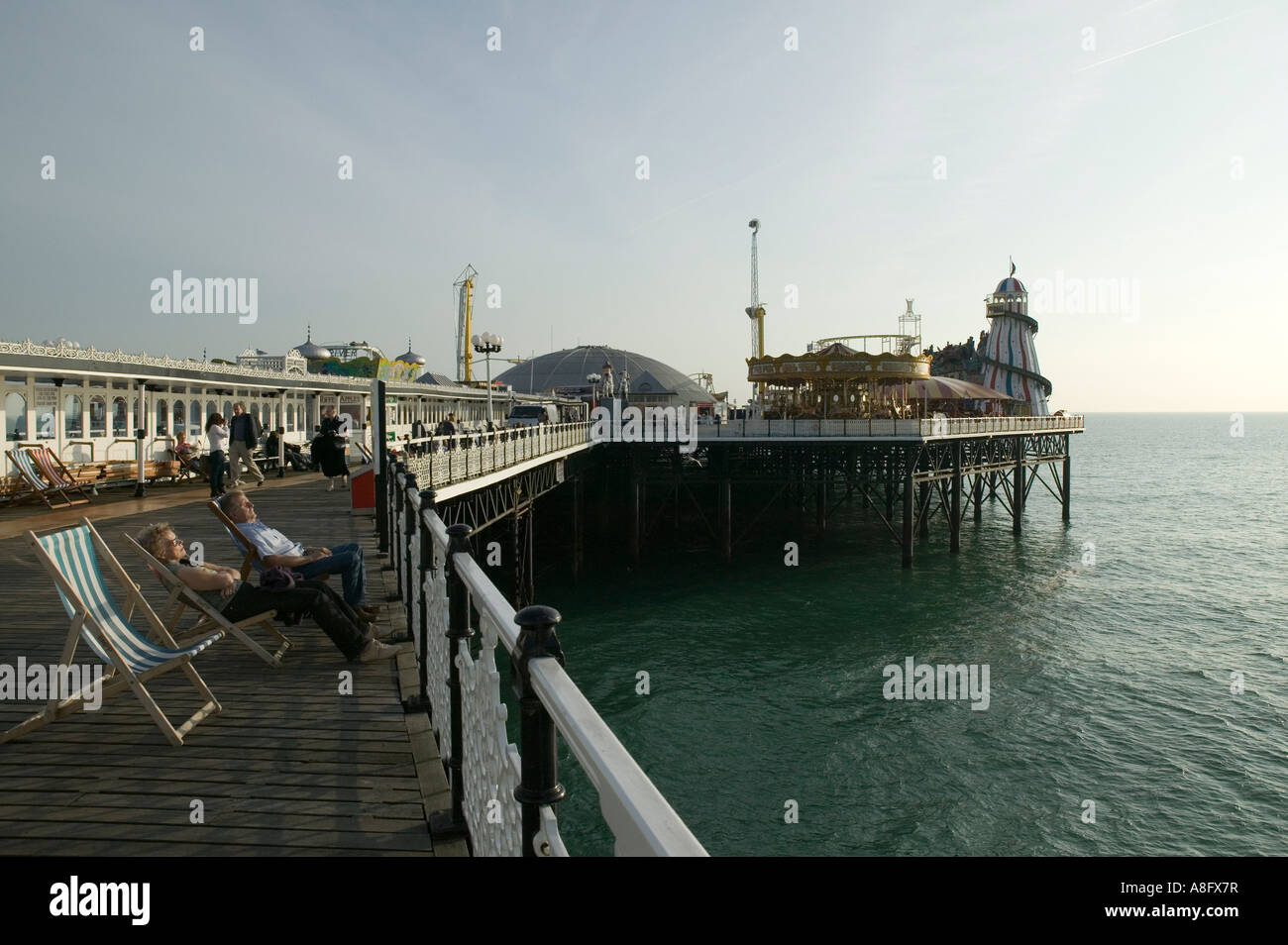Brighton pier deck chairs and fun fair Stock Photo - Alamy
