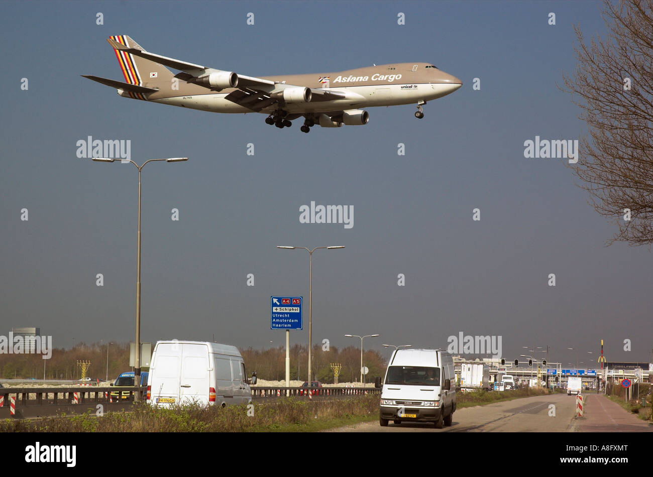 A Boeing 747 Jumbo Jet on short final approach passes low over traffic ...