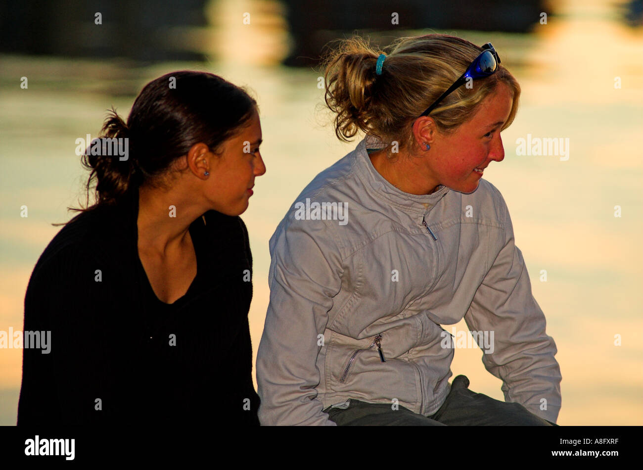 Two teenage girl friends enjoying a summer sunset Stock Photo - Alamy