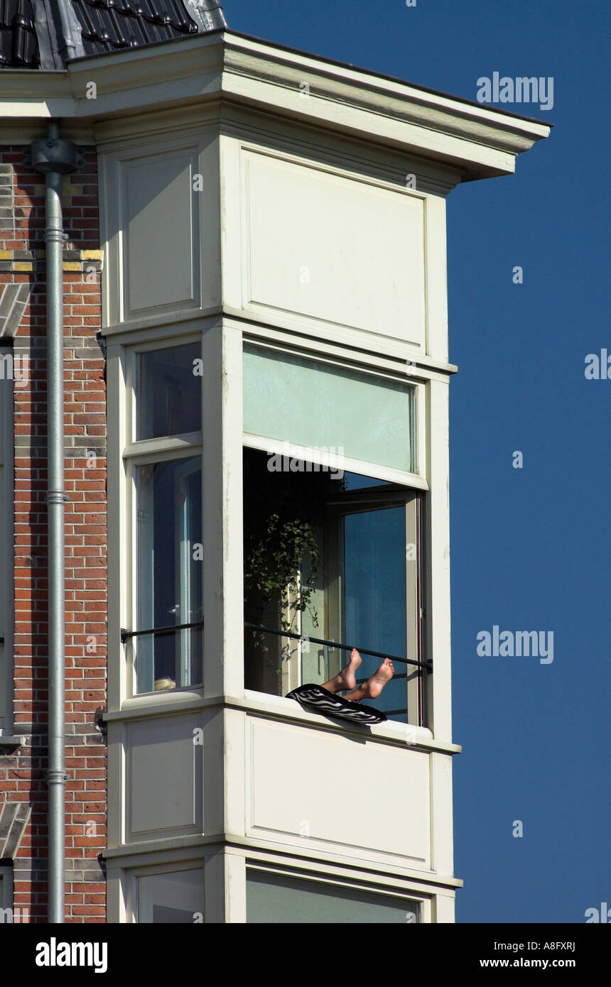 A sunbathers feet sticking out of the window of an apartment in ...