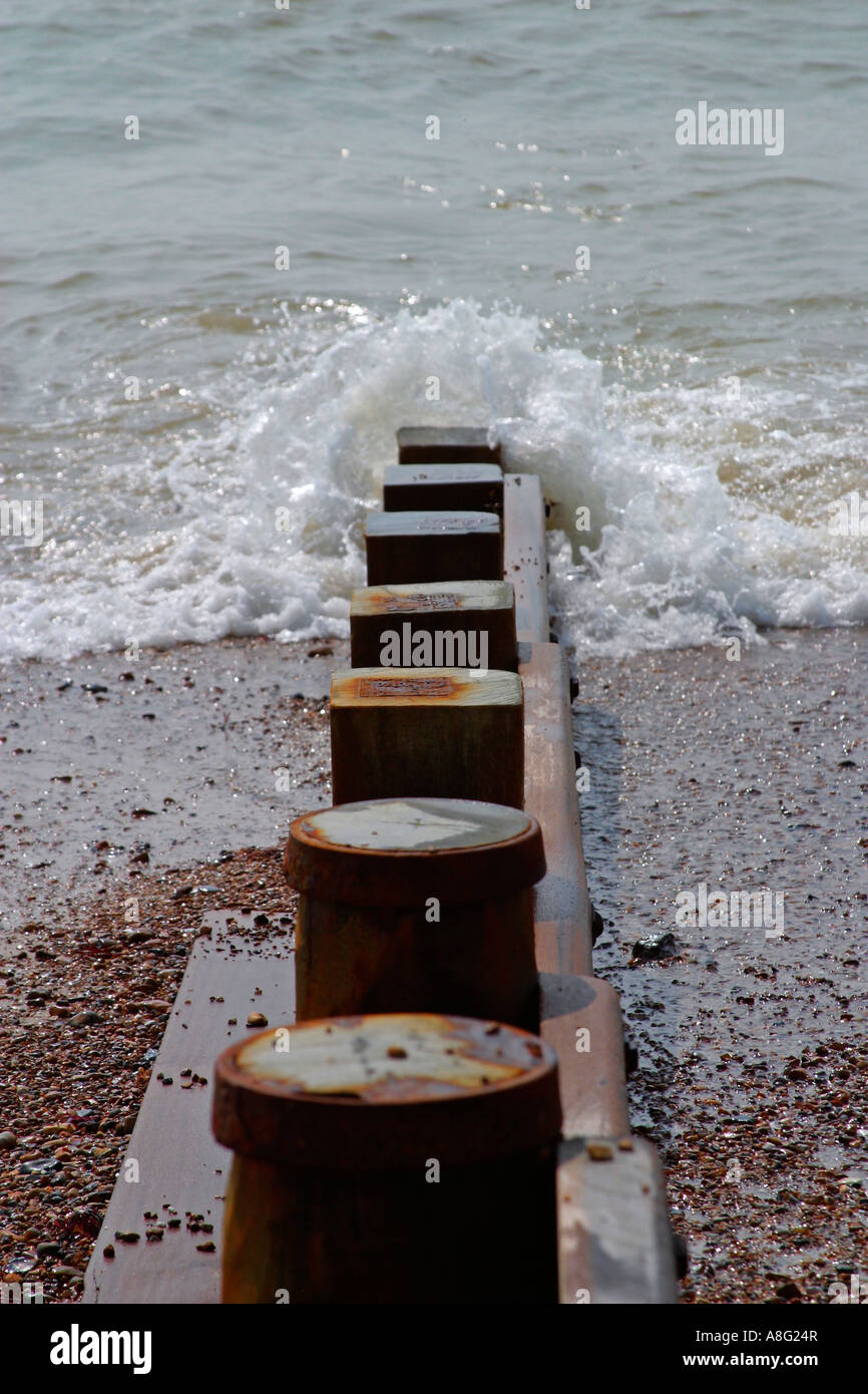 Waves splashing against wooden groynes at Ferring Beach, West Sussex ...