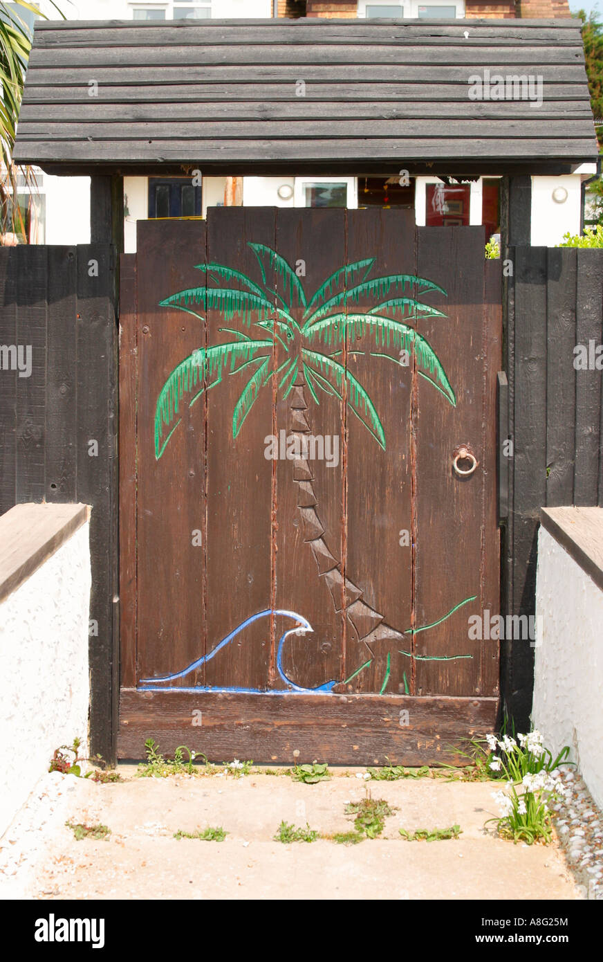 Palm tree painted on wooden back gate of beach house. UK Stock Photo ...