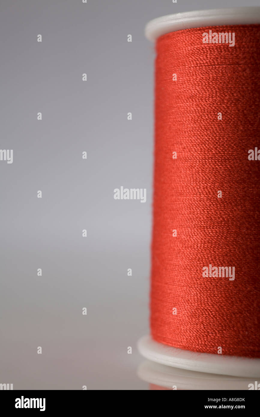 close up of red cotton on its cotton reel Stock Photo - Alamy