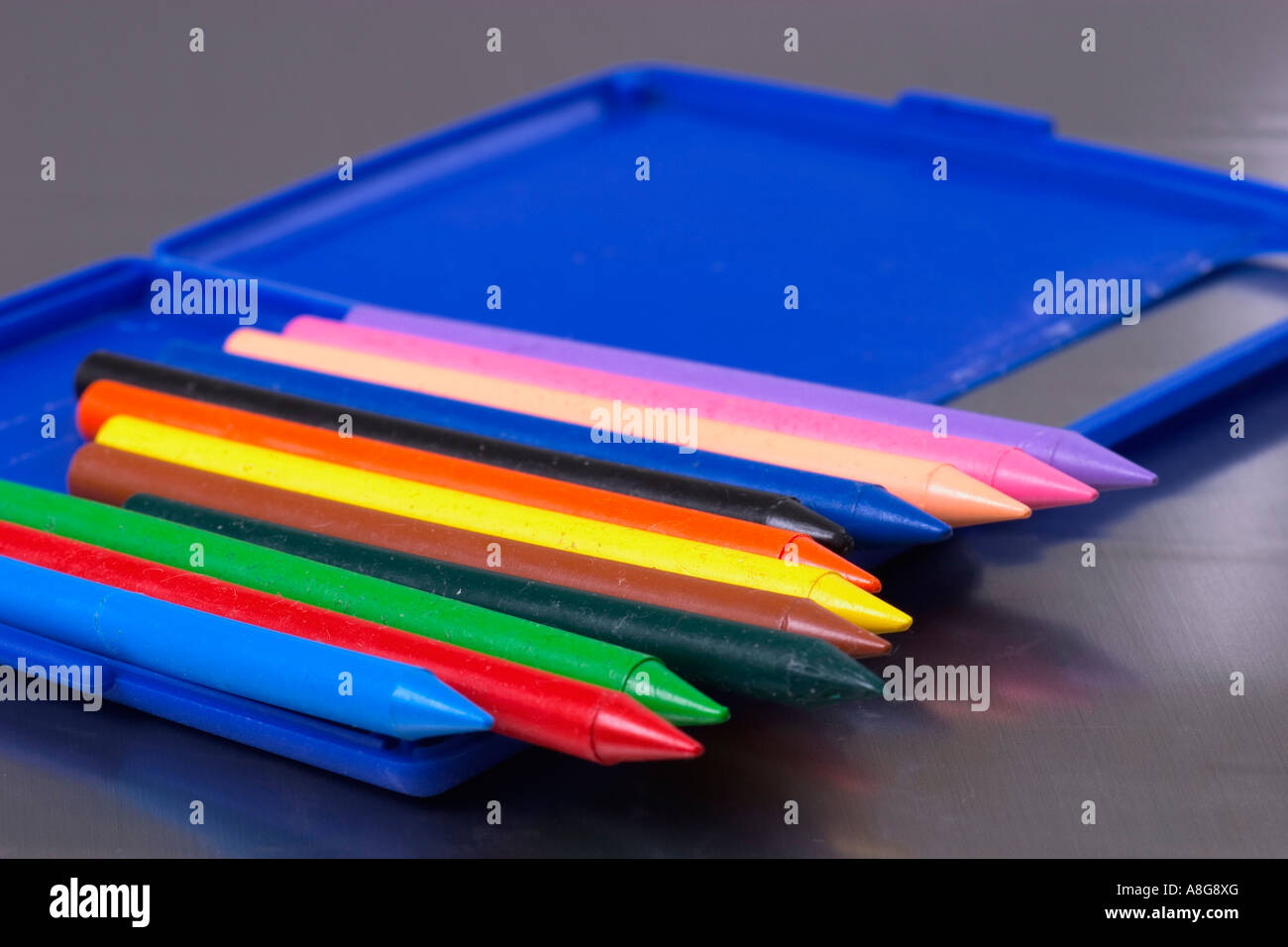 Crayons of different colors on a blue box Stock Photo - Alamy