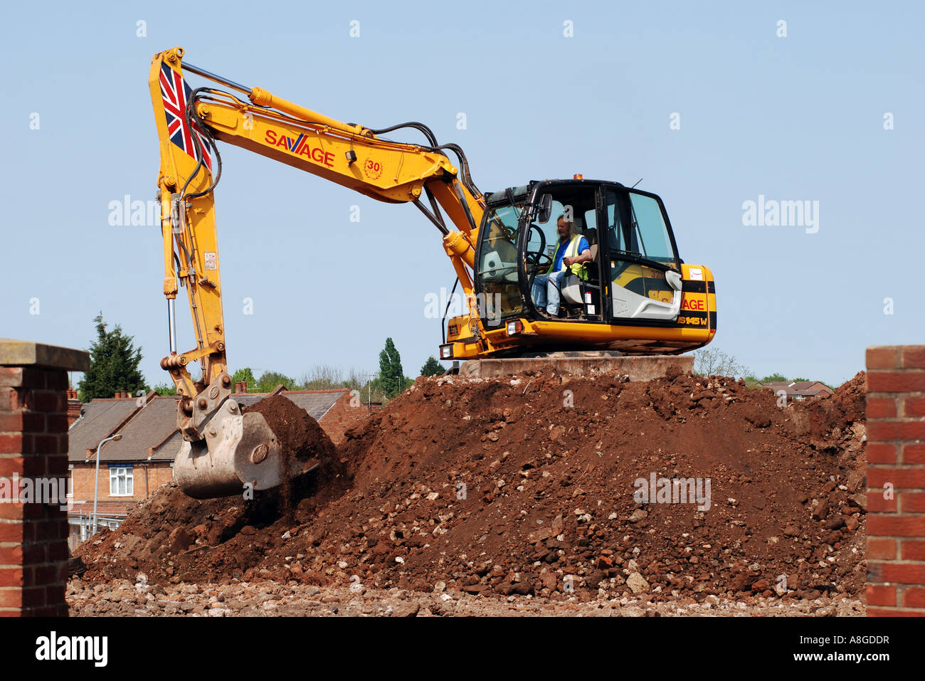 JCB digger moving soil on building site, Warwick, Warwickshire, England ...
