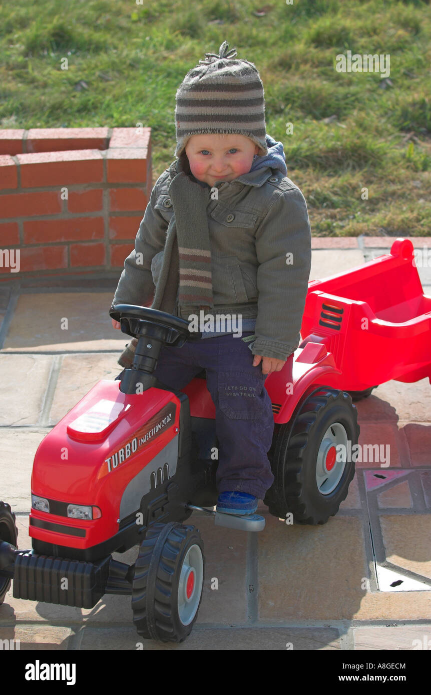 Small boy sitting on toy tractor Stock Photo - Alamy