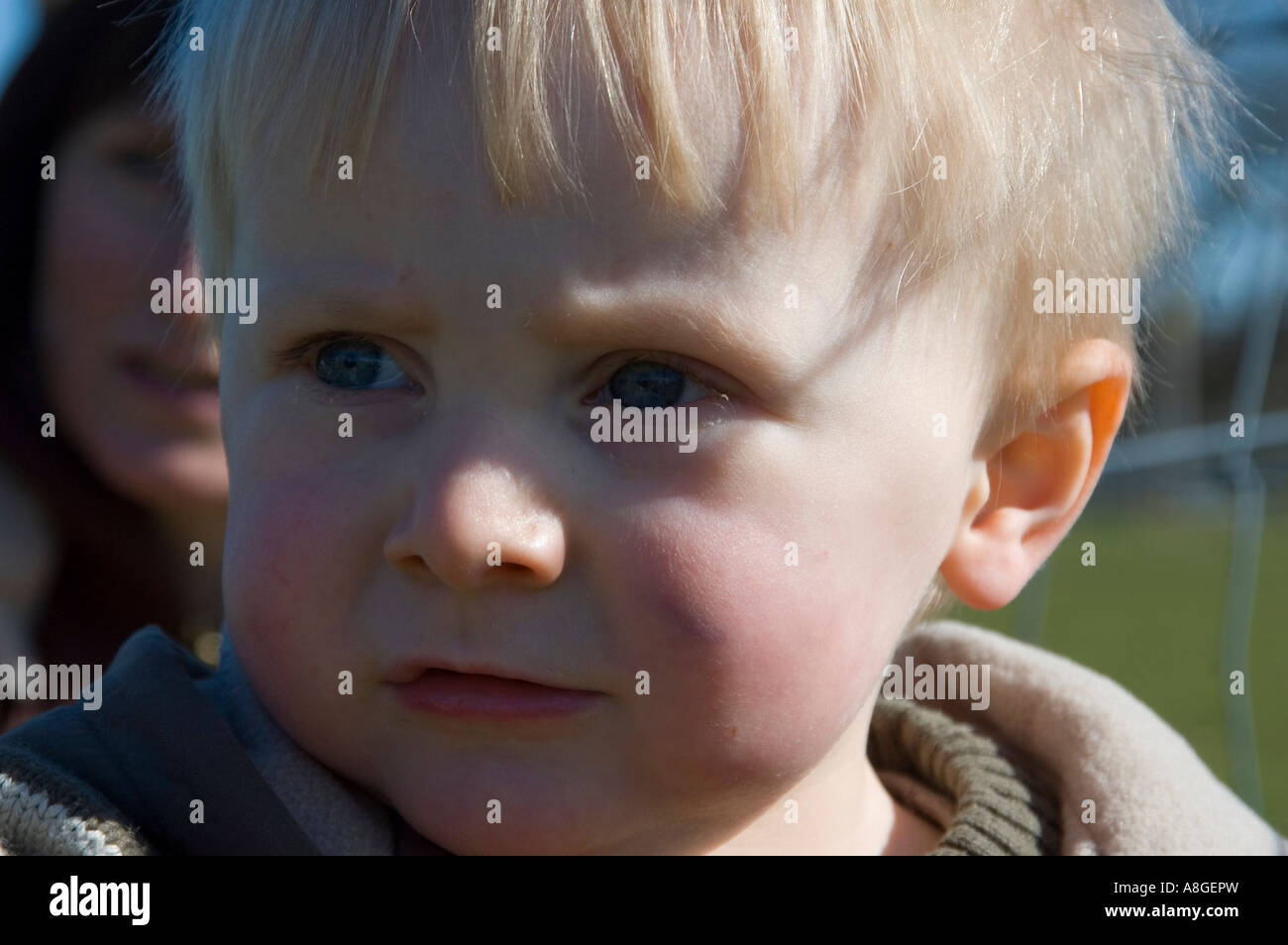 Boy with mother in the background Stock Photo - Alamy