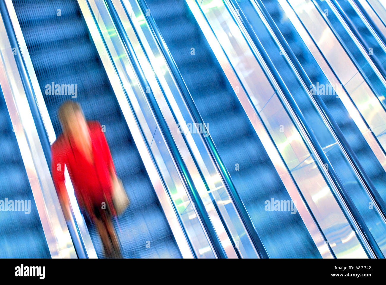Woman riding escalator Stock Photo - Alamy