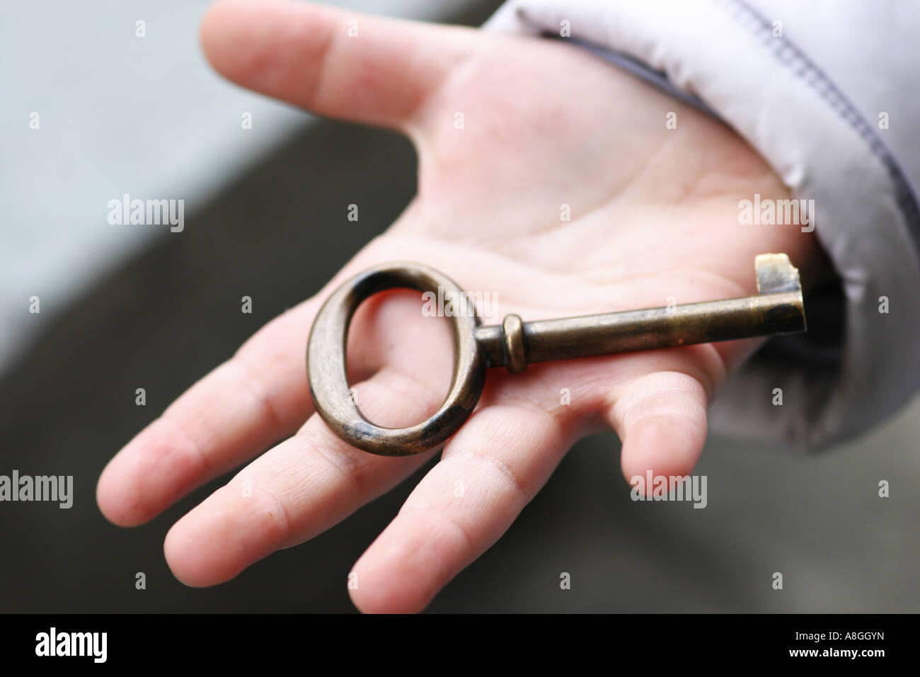 Child's hand holding an old key Stock Photo - Alamy